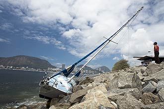 Com vento e mar agitado, veleiro encalha em pedras da praia de Botafogo